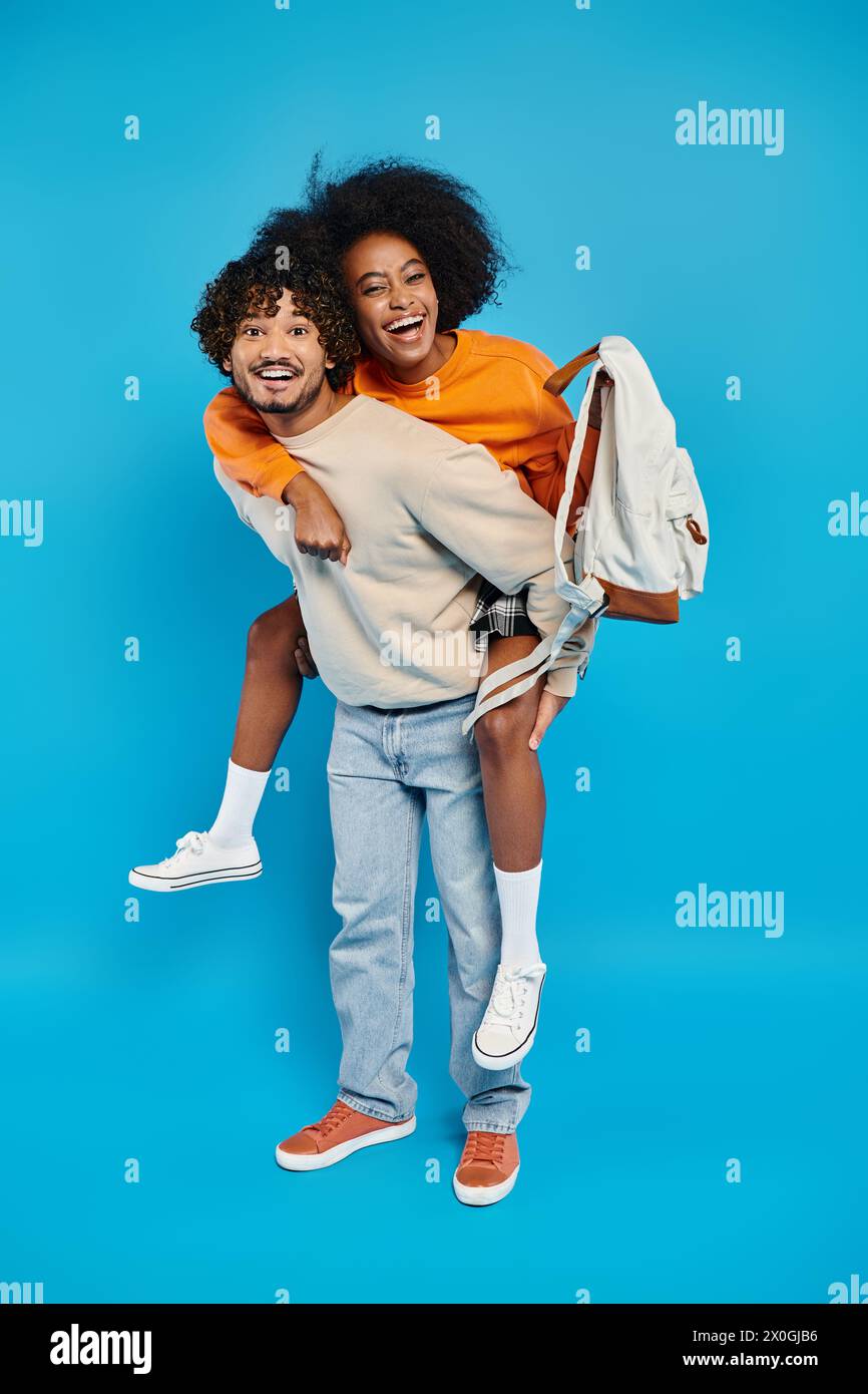 An interracial man supports a woman on his back, showcasing strength ...