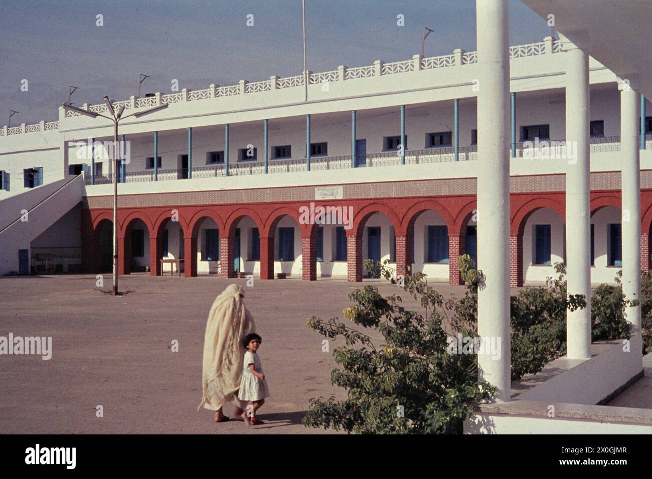 Mother and daughter on the farm in front of a private school with red ...