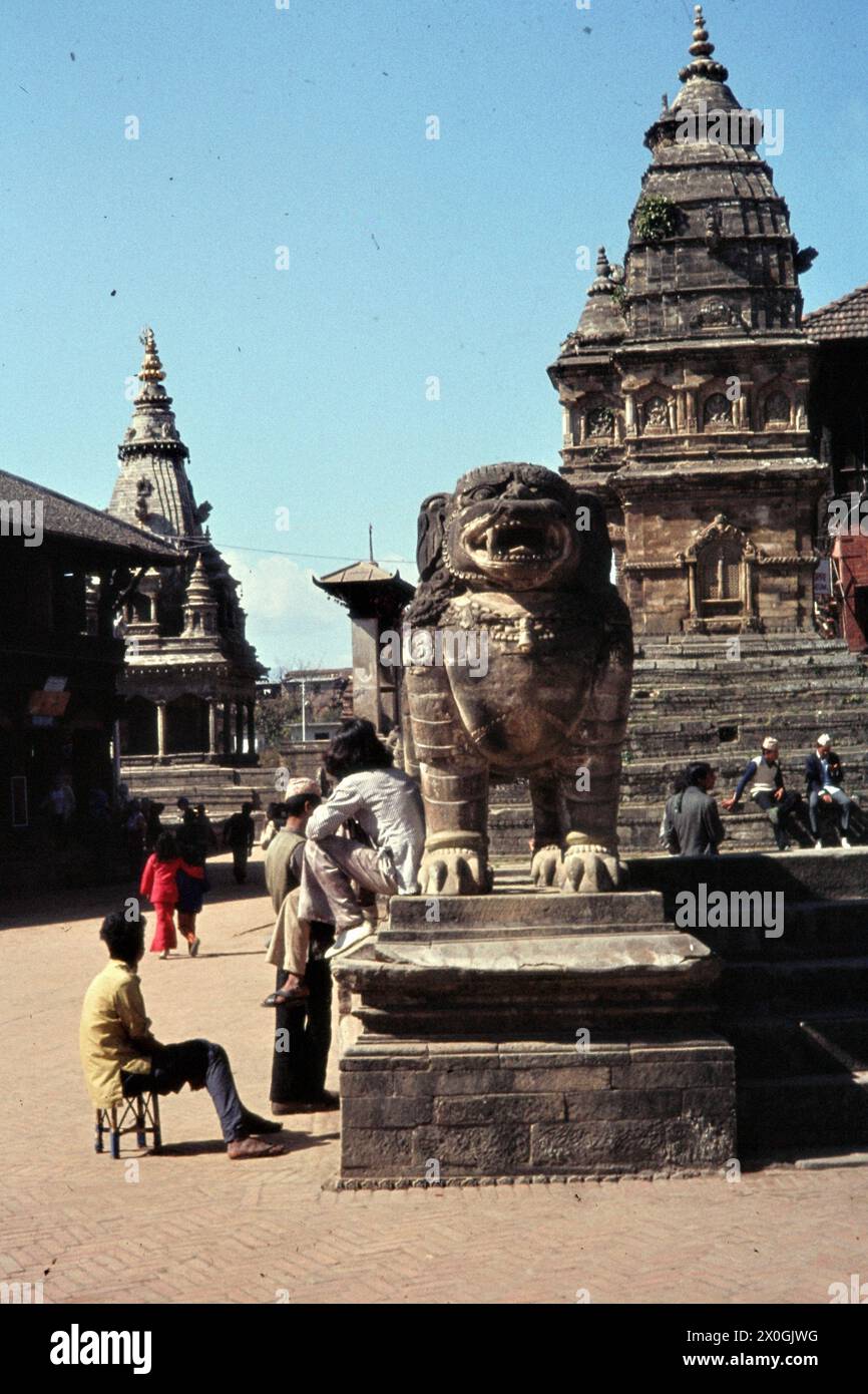 Nepalese men sit at a Siddhi-Lakshmi Mandir statue in front of the ...