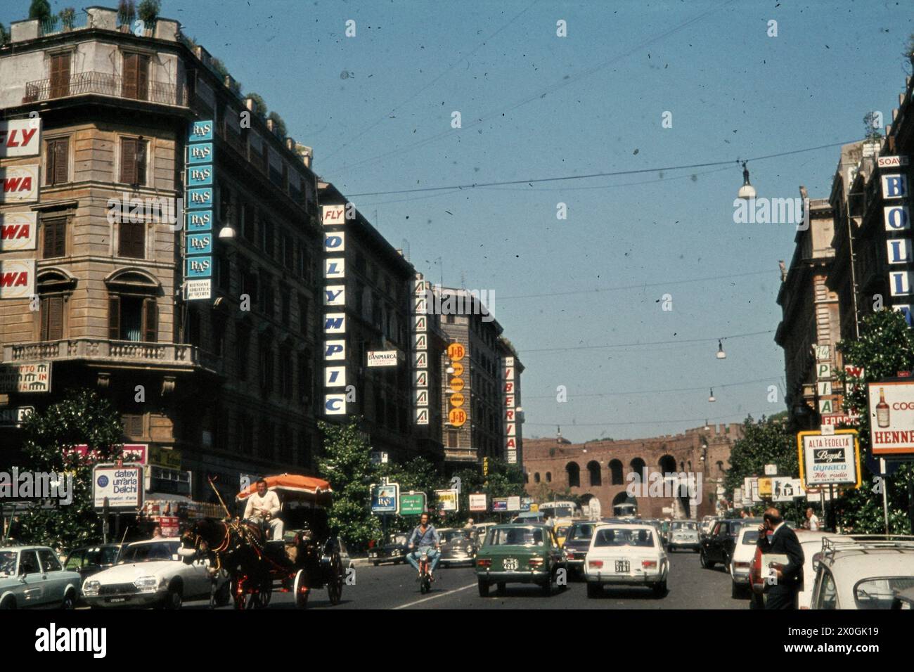 A horse-drawn carriage and cars on the street Via Vittorio Veneto in ...