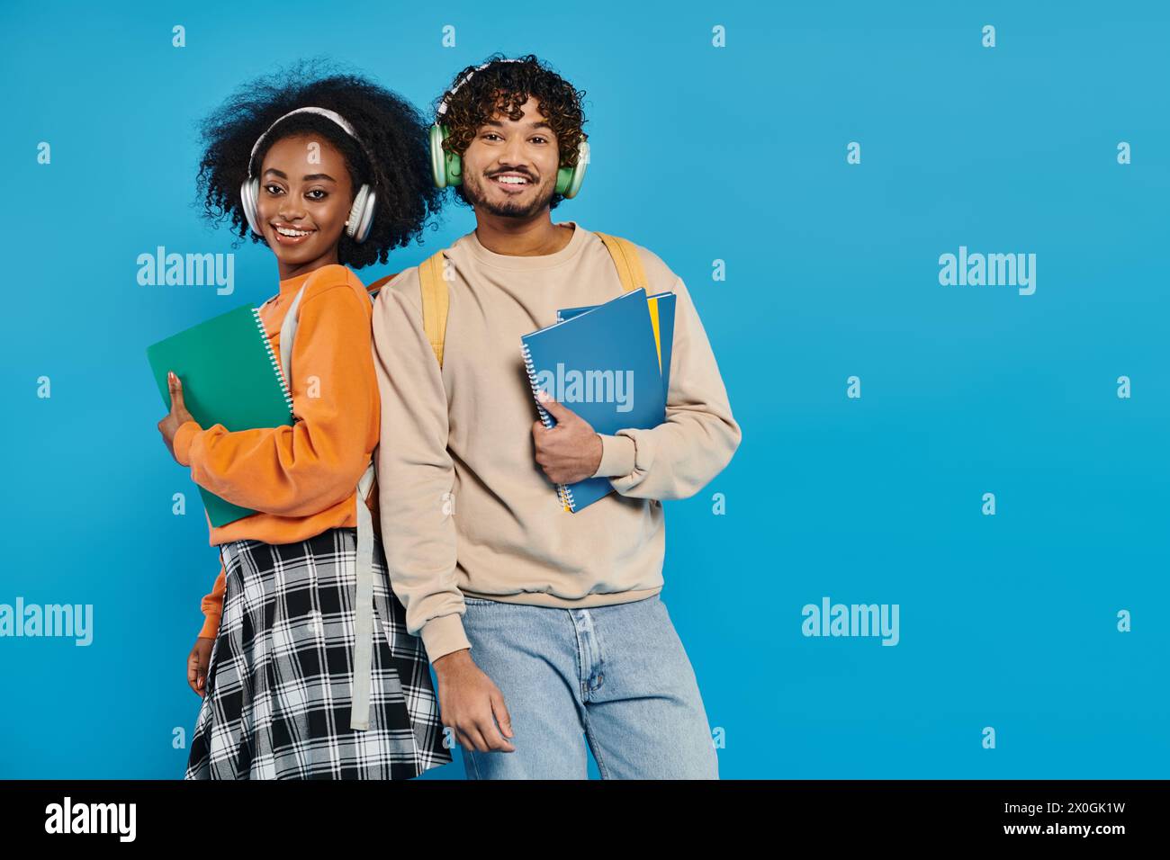 A man and a woman of different races standing together in casual attire ...