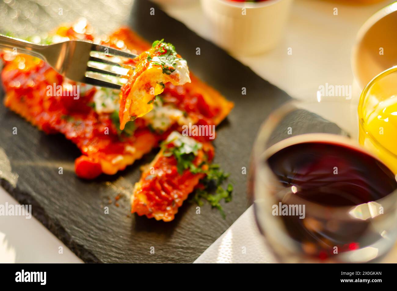 Four cheese filled ravioli in a tomato and basil sauce on the black ...