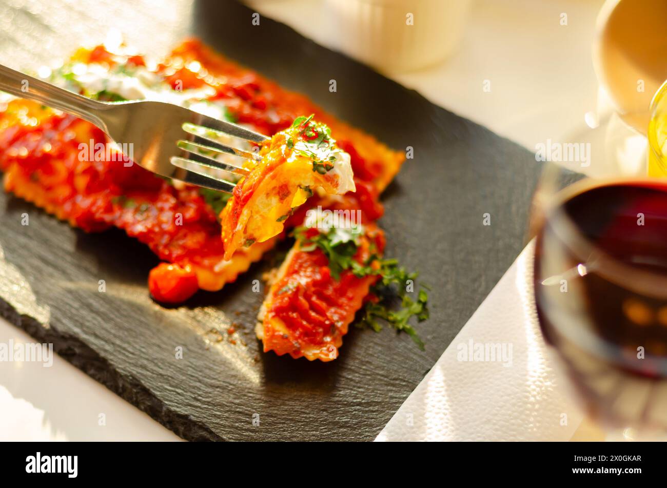 Four cheese filled ravioli in a tomato and basil sauce on the black ...