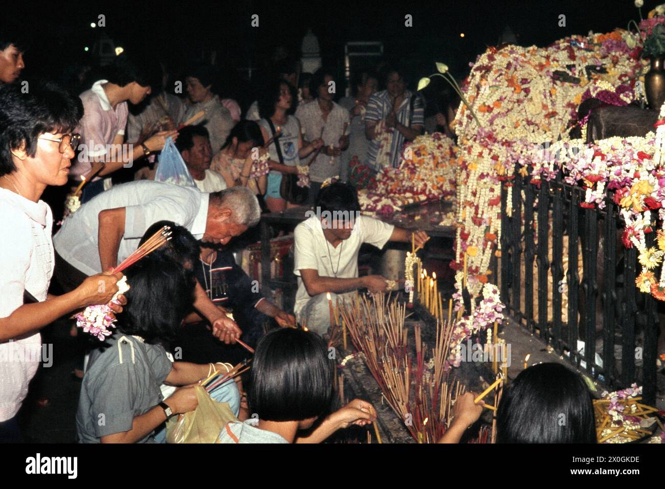 People light candles during a sacrificial ceremony in Bangkok ...