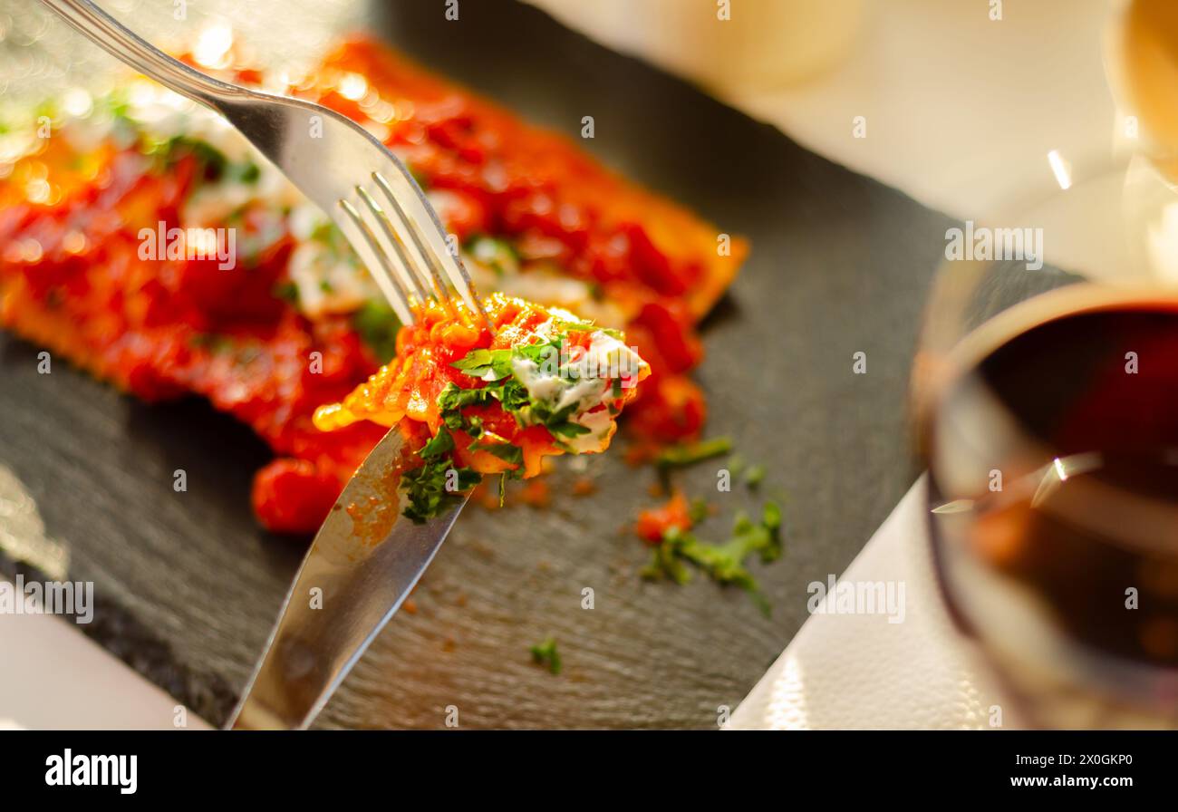 Four cheese filled ravioli in a tomato and basil sauce on the black ...