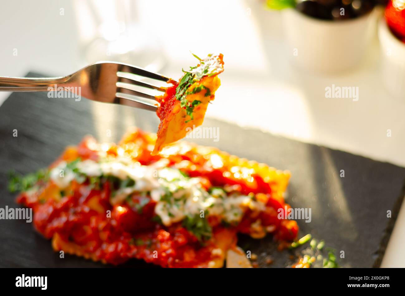 Four cheese filled ravioli in a tomato and basil sauce on the black ...