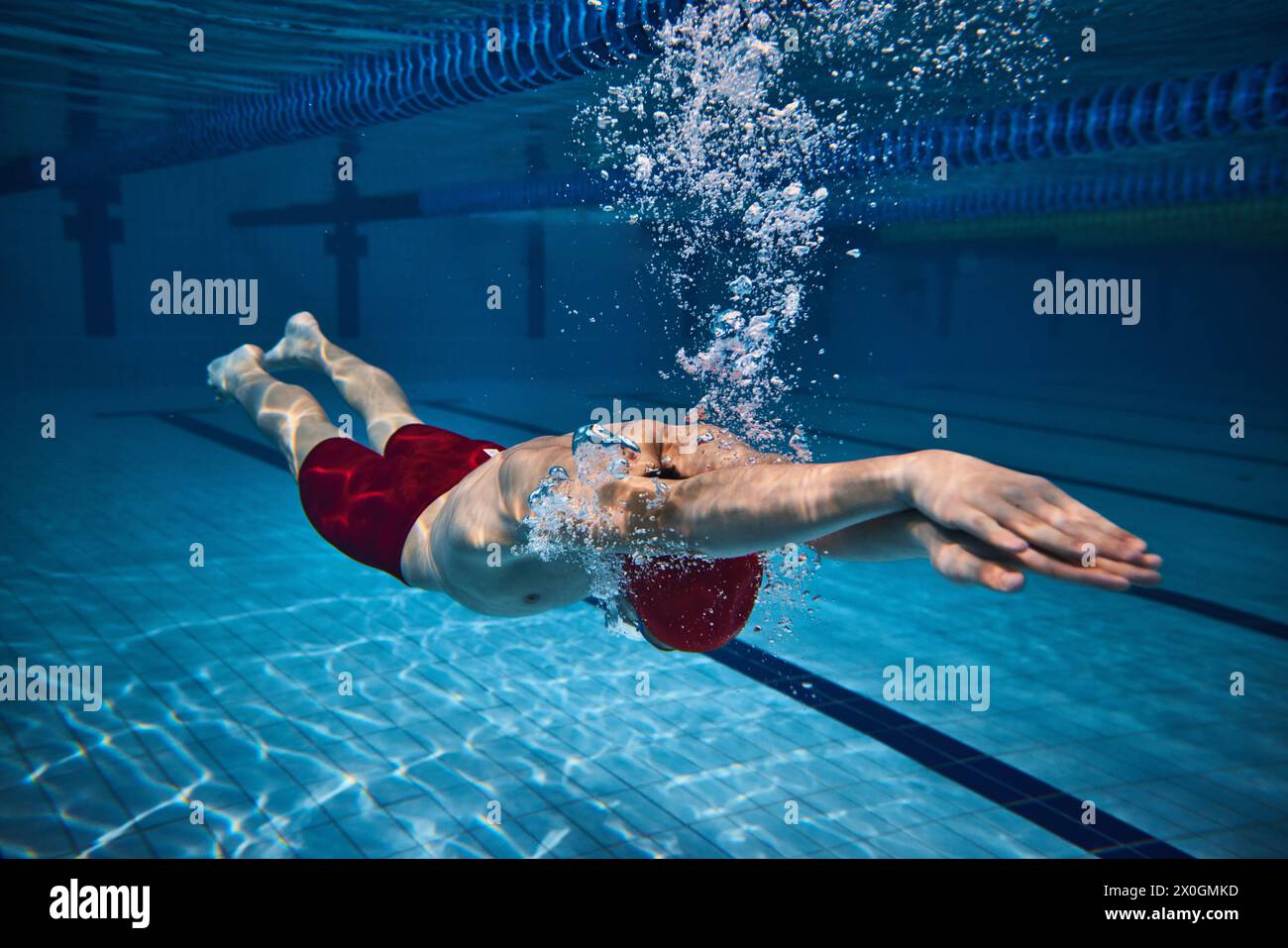 Dynamic image of athletic young guy, swimmer in cap in motion ...