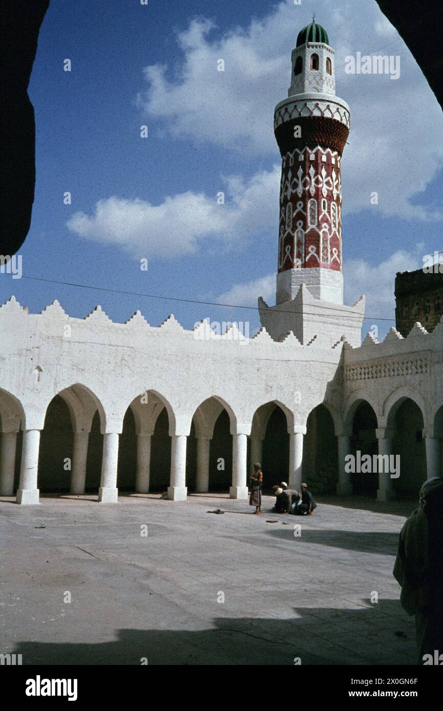 Praying Muslims in front of the arcades in the courtyard and the ...