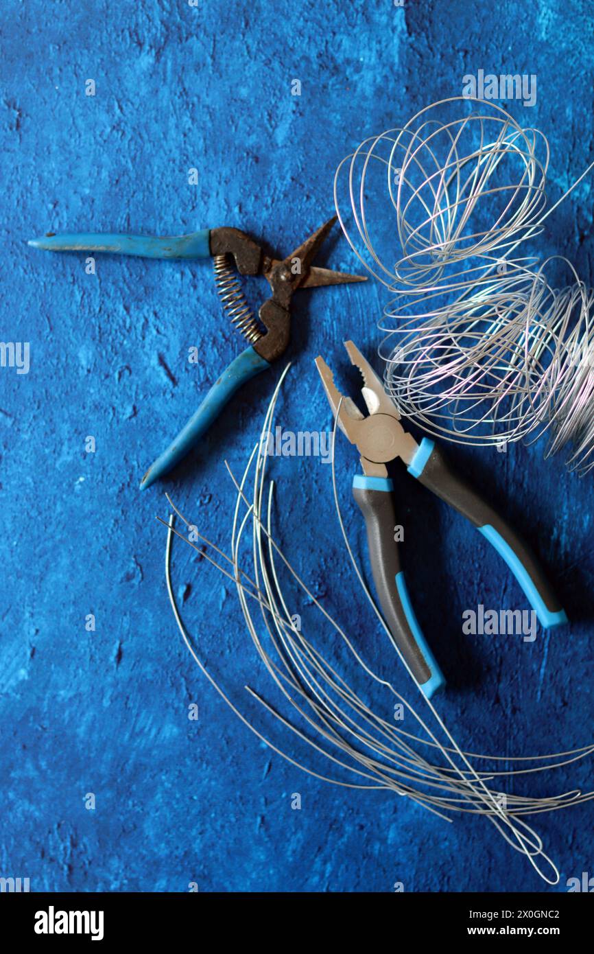 Tools on blue textured background with copy space. Vintage pliers close ...