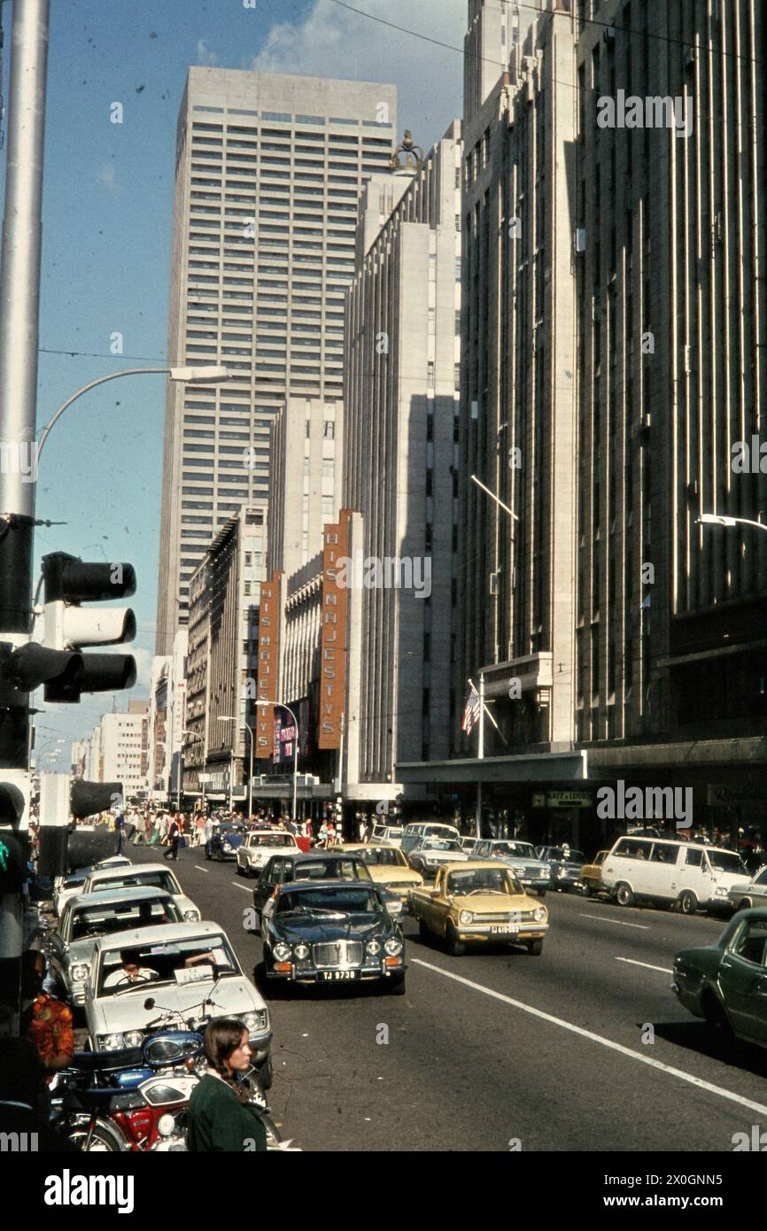Cars drive between high-rise buildings on Commissioner Street in ...