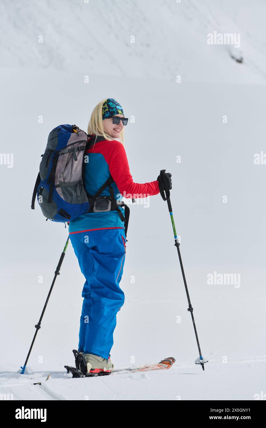 A professional woman skier rejoices after successfully climbing the ...