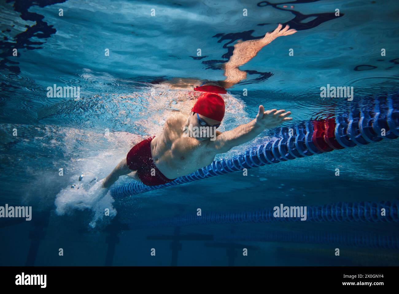 Powerful strokes. Freestyle swimming type. Young man, swimmer in motion ...