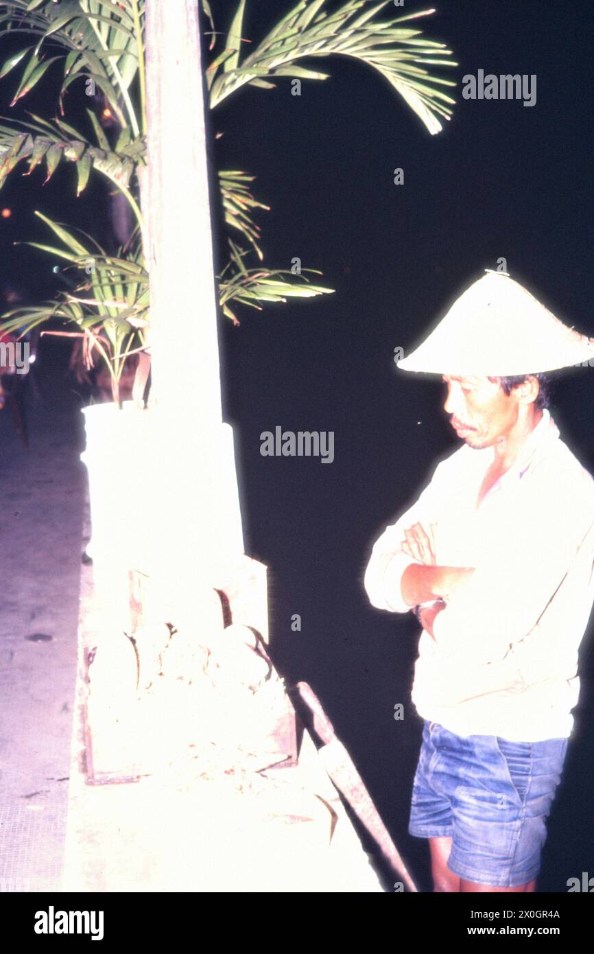 A man sells seashells shells at night on the beach of Zamboanga ...
