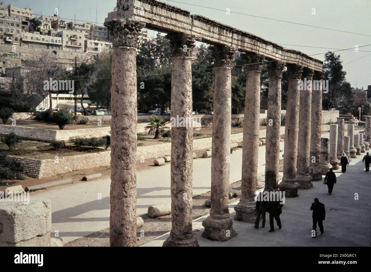 People pass a row of columns on a street in front of the theatre in ...