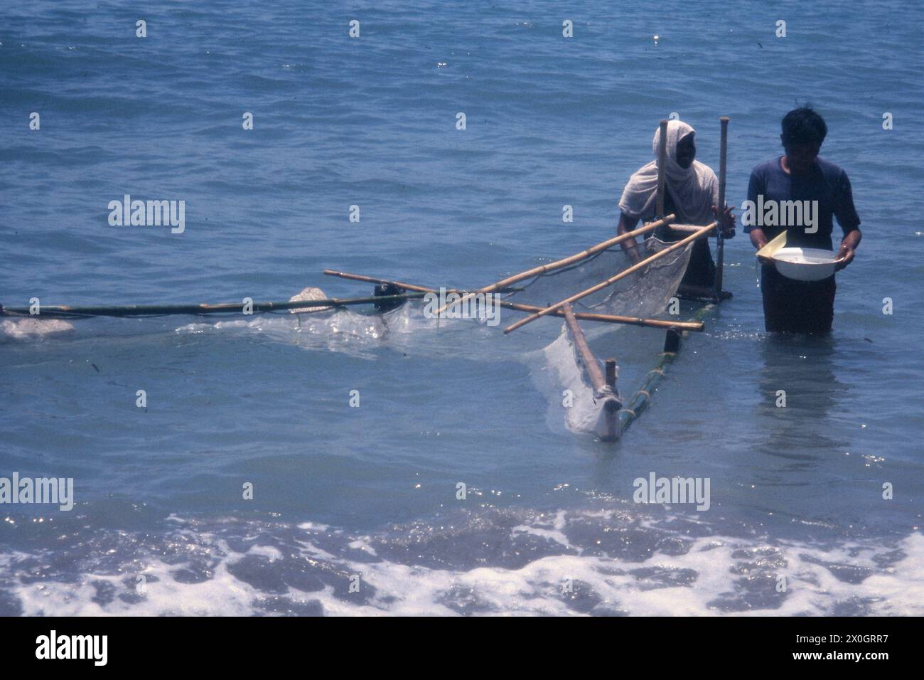 Two fishermen with self-made landing nets on the beach of San Ramon ...