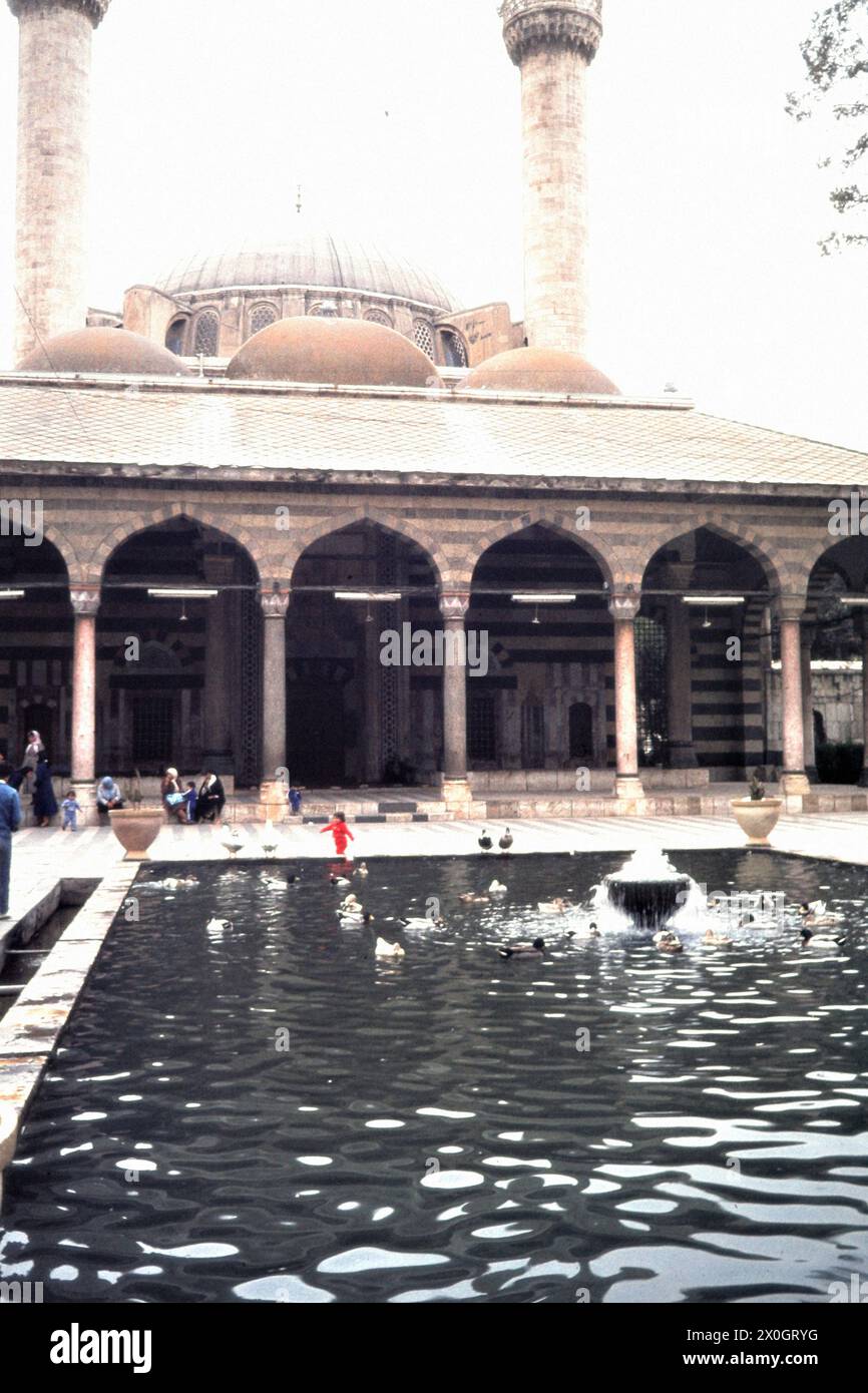 People at the water basin in front of the Tekkiye Mosque in Damascus ...