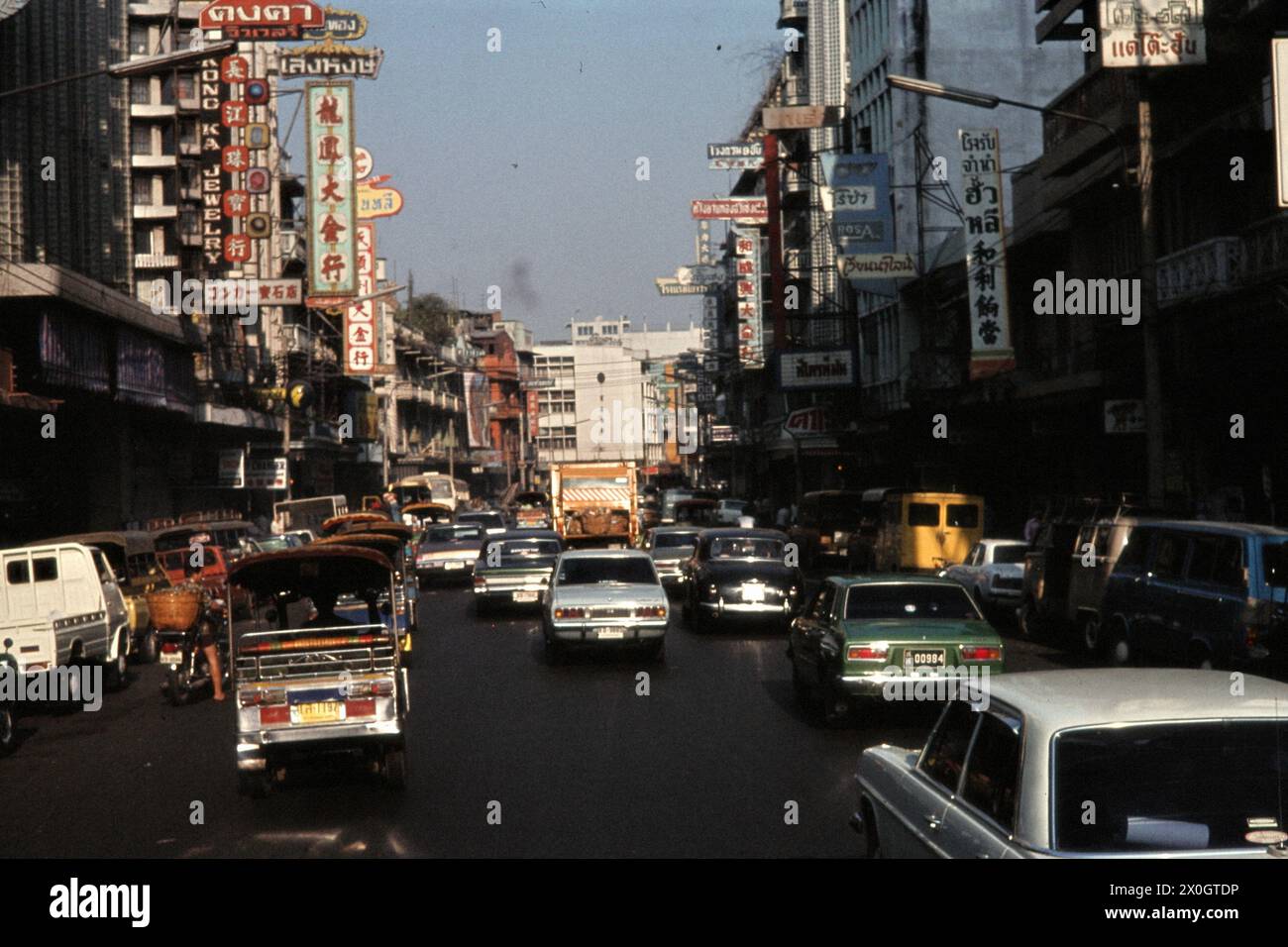 A busy main street with advertising signs on the building facades in ...