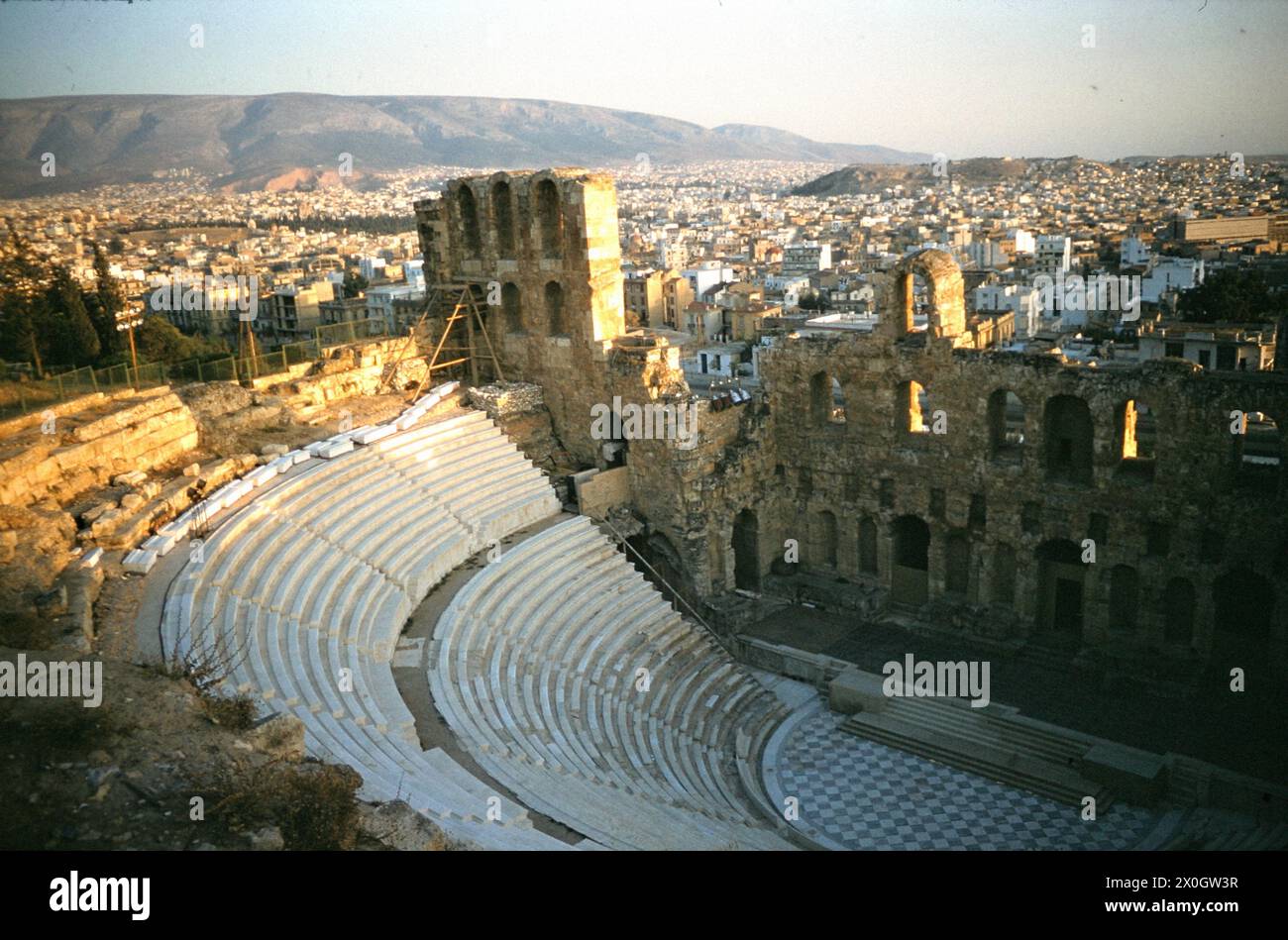 The Odeon of Herodes Atticus at sunset with the city of Athens in the ...