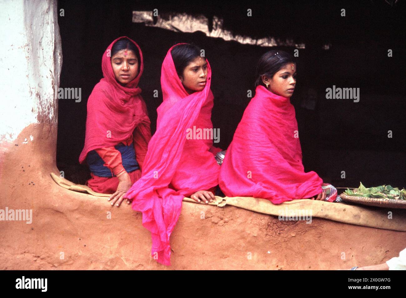 Three Nepali girls in traditional robes sitting in a window in the ...