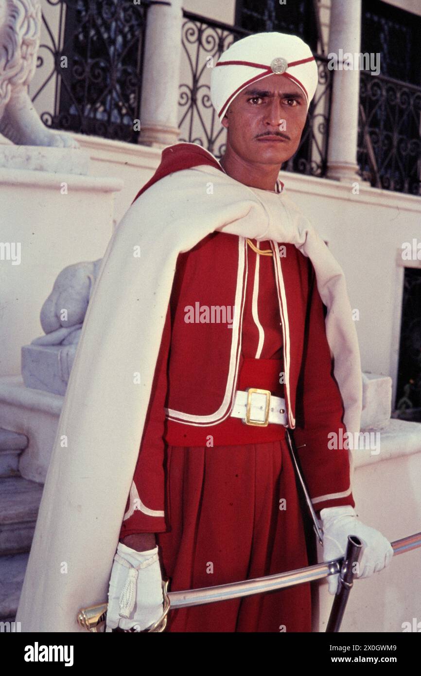 A red-clad guard with a sabre in front of the entrance to the ...
