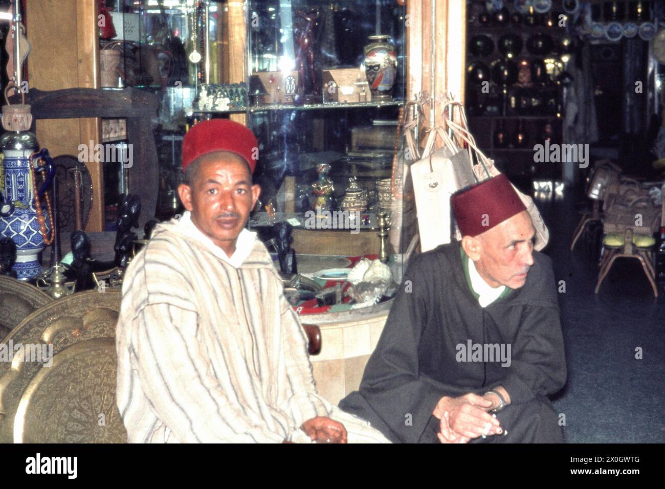 Men with fez in a conversation at night outside a shop in Tangier ...
