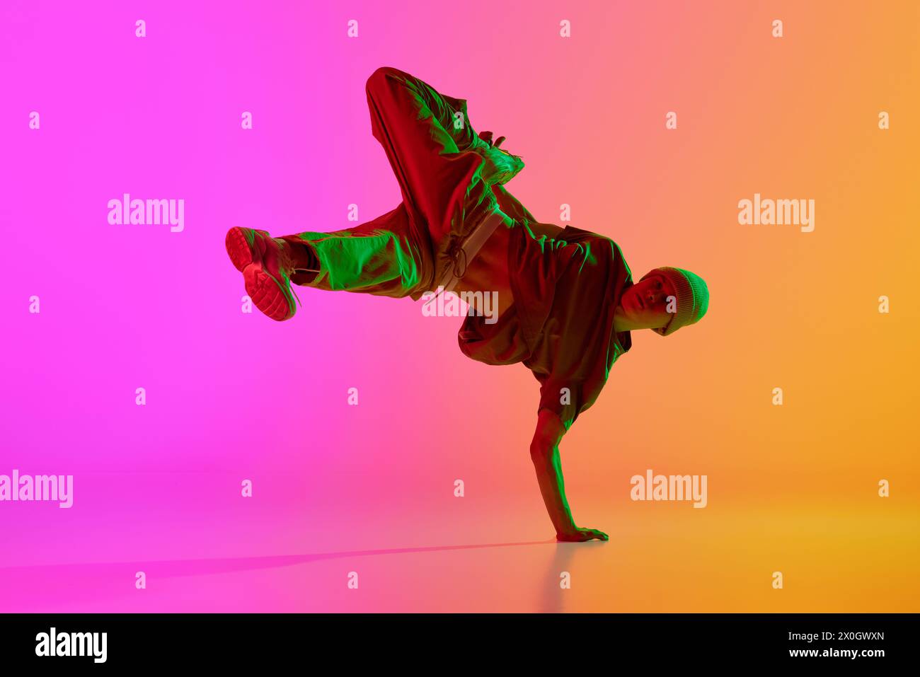 Dynamic photo of young, stylish dressed man dancing in neon light ...