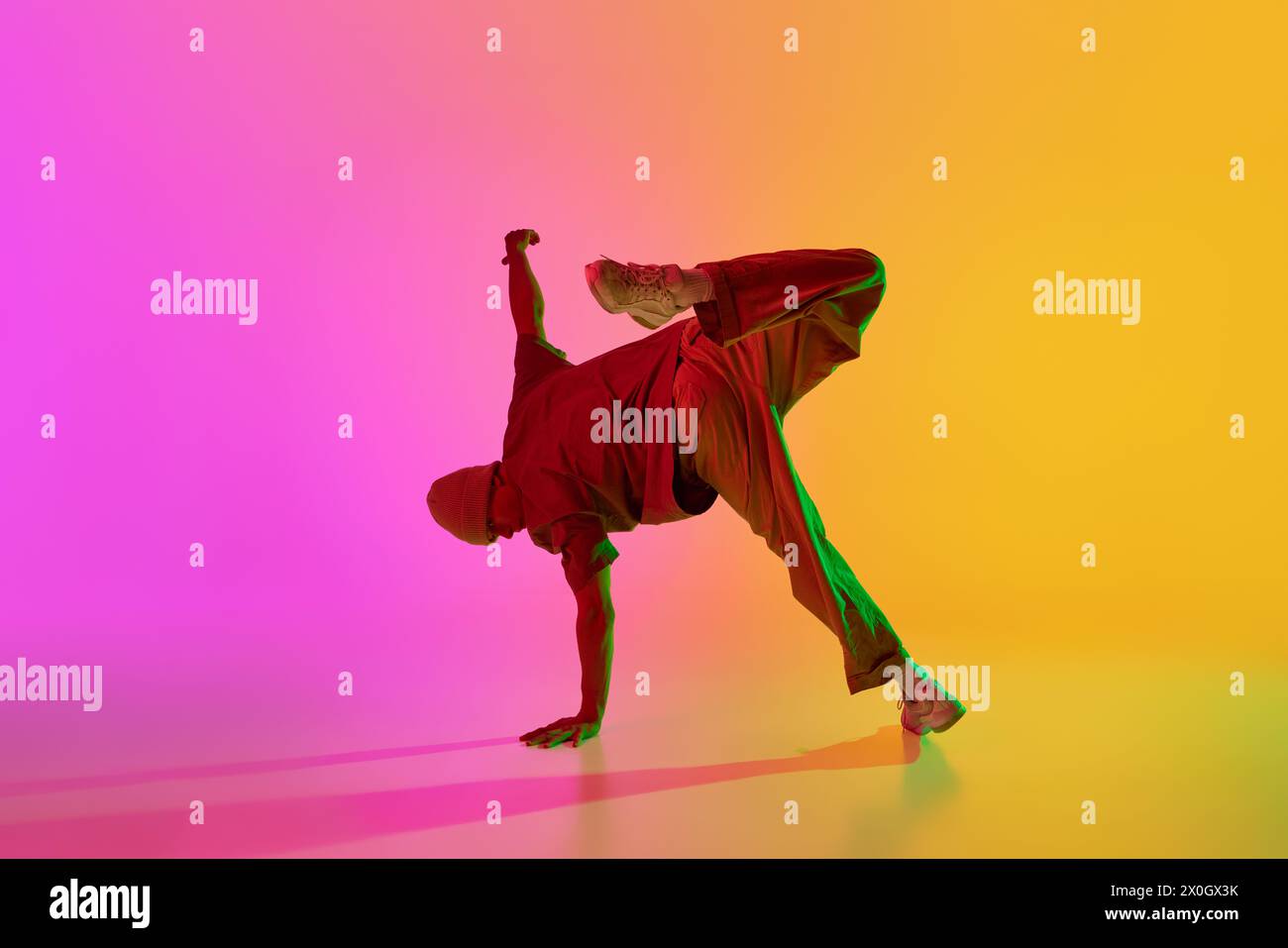 Dynamic photo of young, stylish dressed man breakdancer posing in neon ...