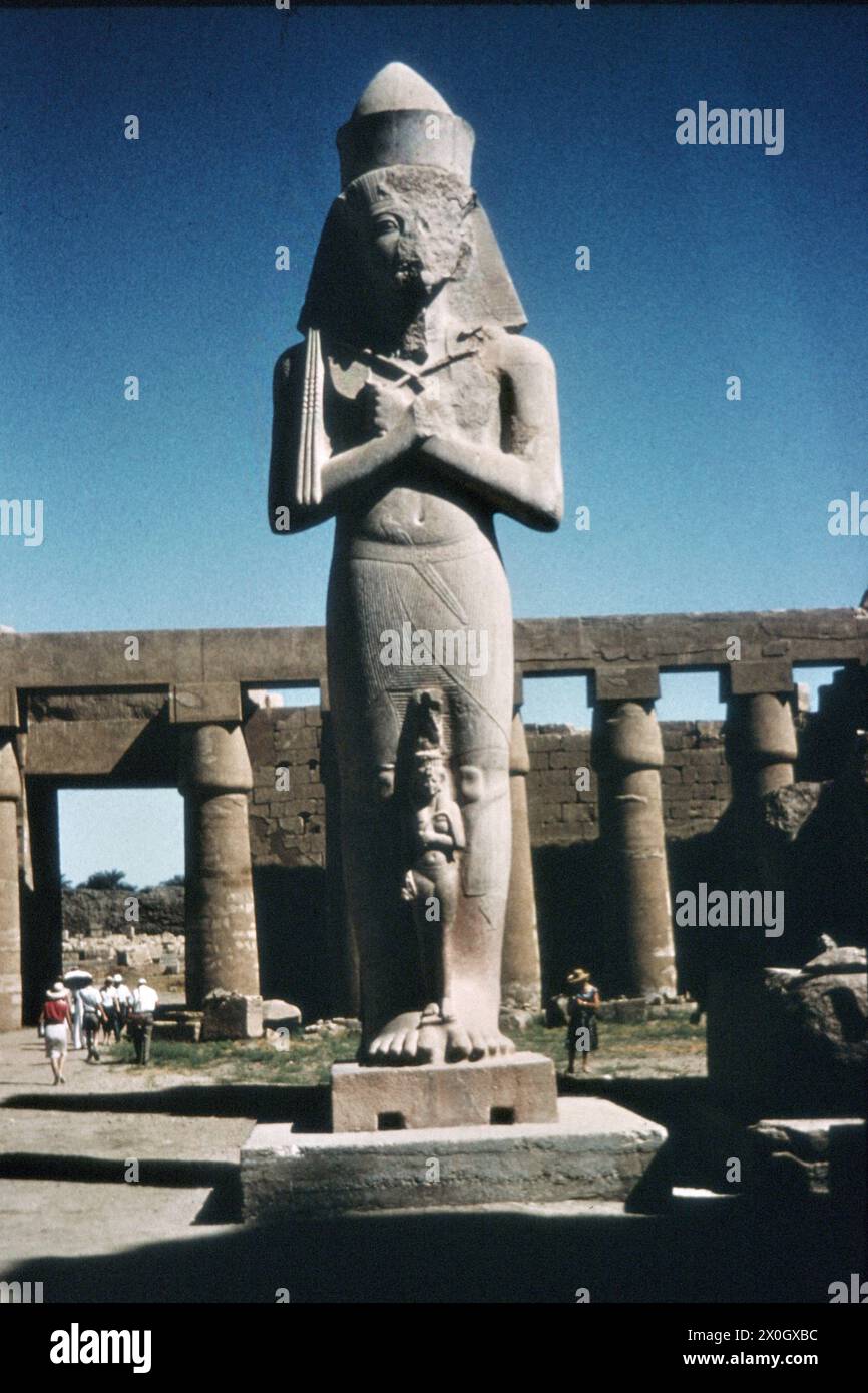 Tourists next to the colossal statue of Ramses II, with a smaller ... Tourists next to the colossal statue of Ramses II, with a smaller ...