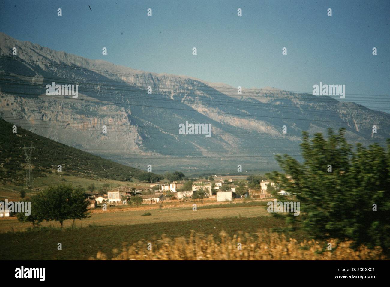 View over a village and fields to the Parnass Mountains in central ...