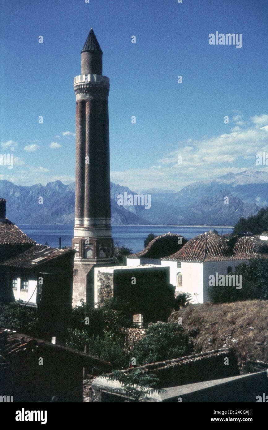 The minaret of the Yivli Minare Mosque in Antalya with the mountains at ...