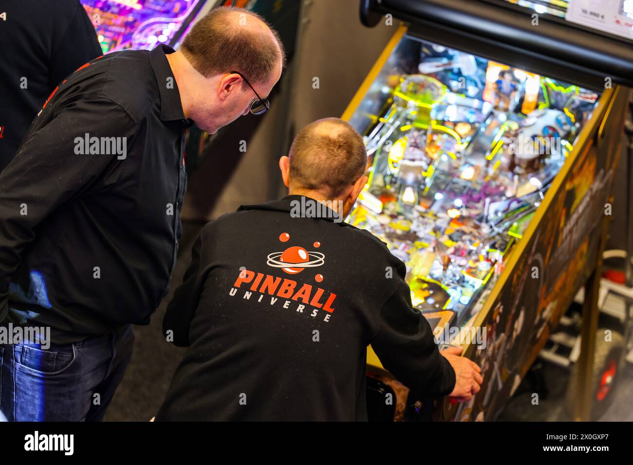Gronau, Germany. 12th Apr, 2024. Participants stand at pinball machines ...