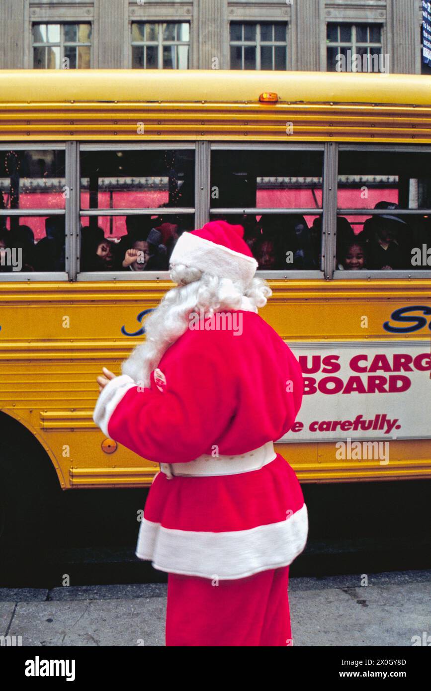 Santa Claus on 5th Avenue in Midtown in front of a school bus ...