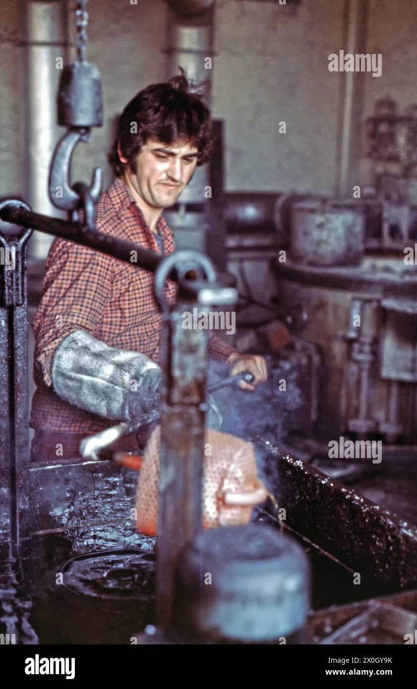 A young man in the hardening shop hardening steel and aluminium ...