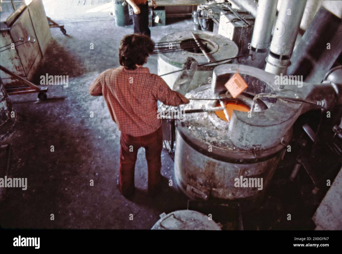 A young man in the wage hardening shop hardening steel and aluminium ...