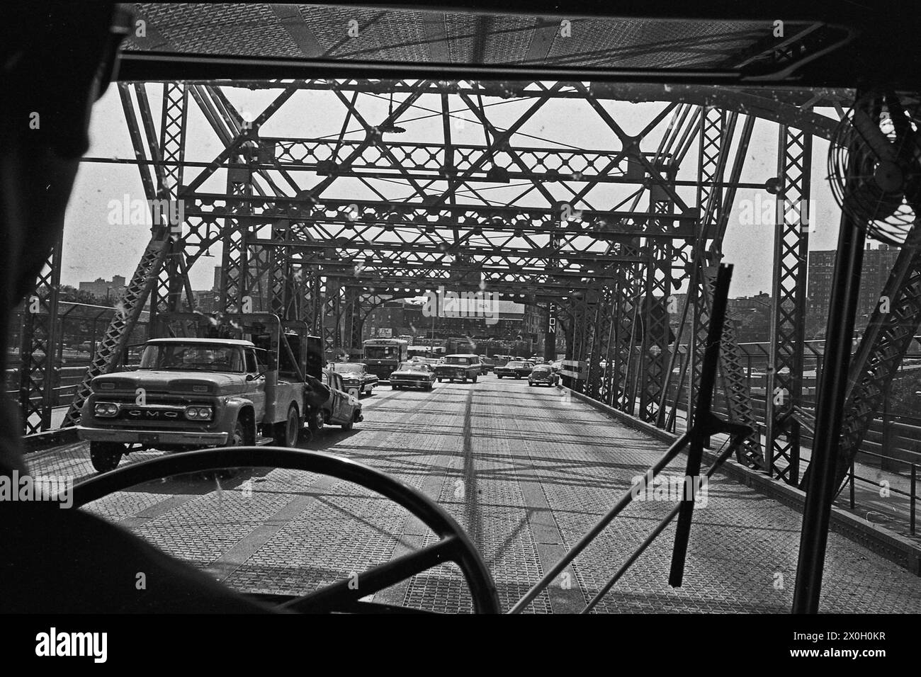 View from the windshield of a bus on a steel bridge filled with cars in ...