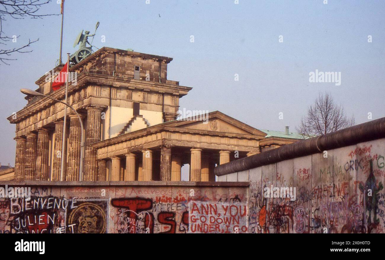 The Brandenburg Gate and the Berlin Wall in Berlin. Left, the flag of ...