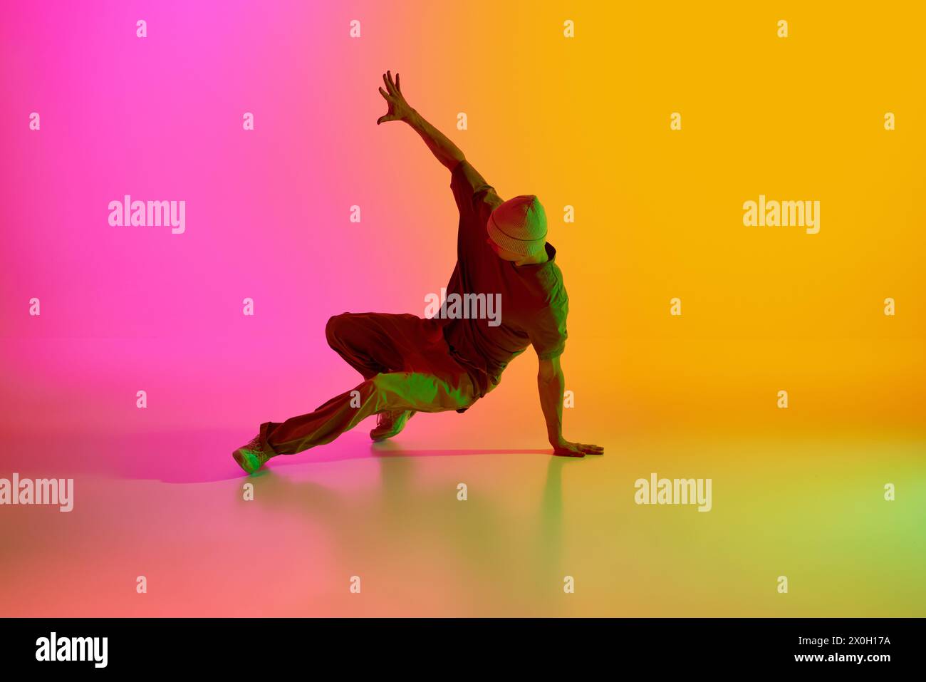 Young man, dressed streetwear performing freestyle moves in motion in ...