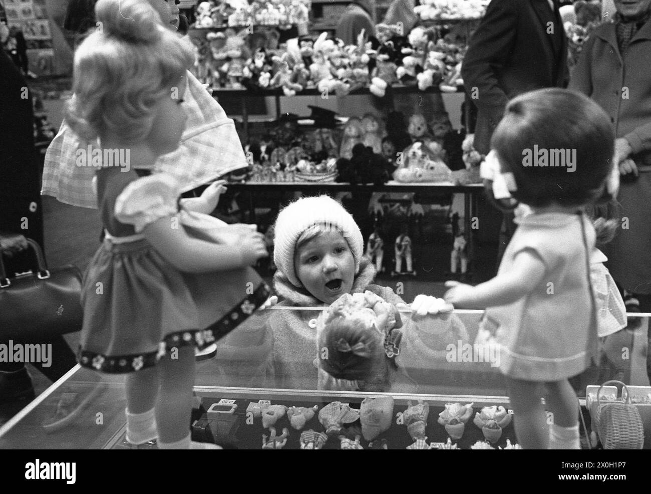 A child is in a toy store with her parents. In the picture, the little ...