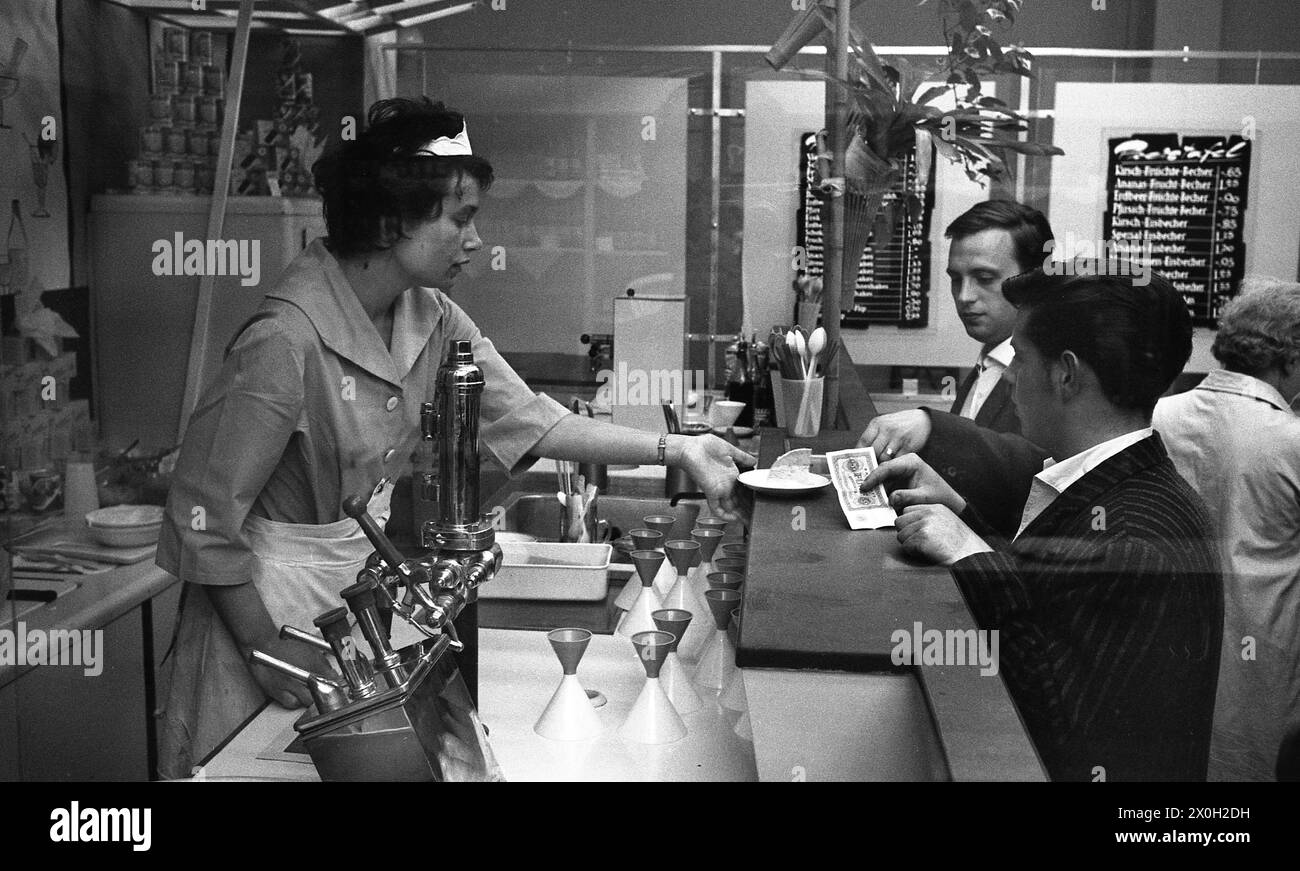 Two young men pay at the checkout counter of a snack bar at the ...
