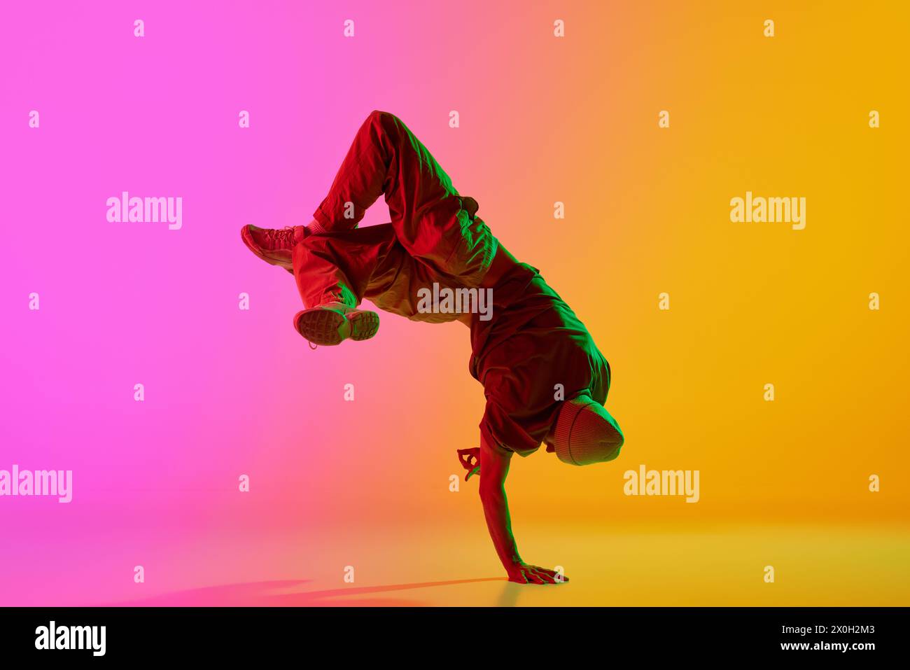 Dynamic photo of young, talented man dancing breakdance moves in neon ...