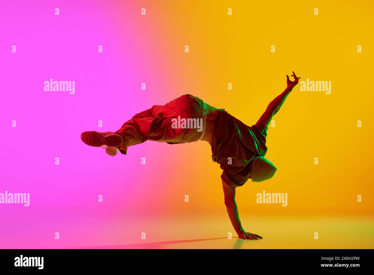 Dynamic photo of young, talented man dancing freestyle moves in neon ...