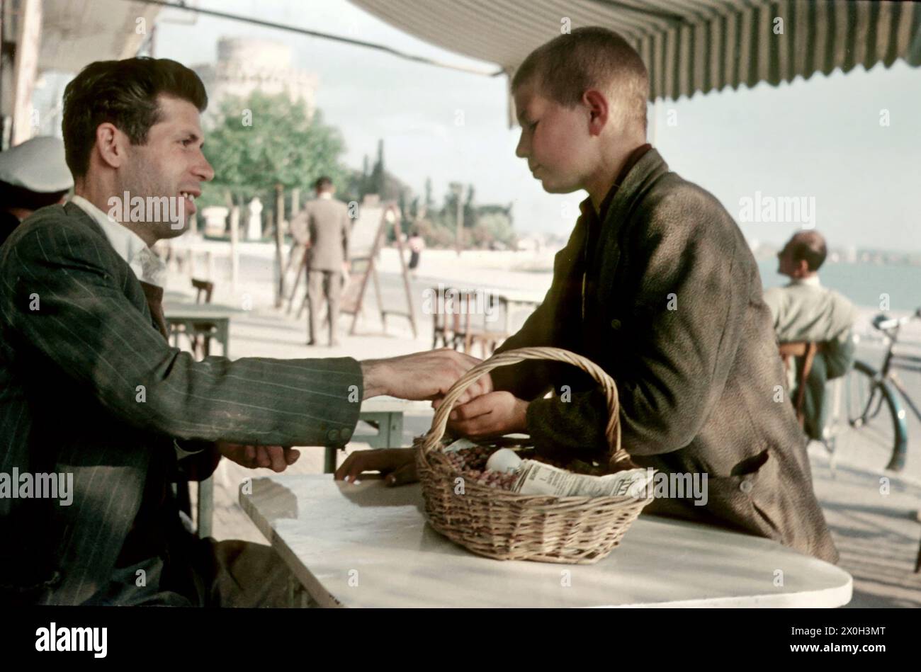 A boy gets money in a street cafe Stock Photo - Alamy