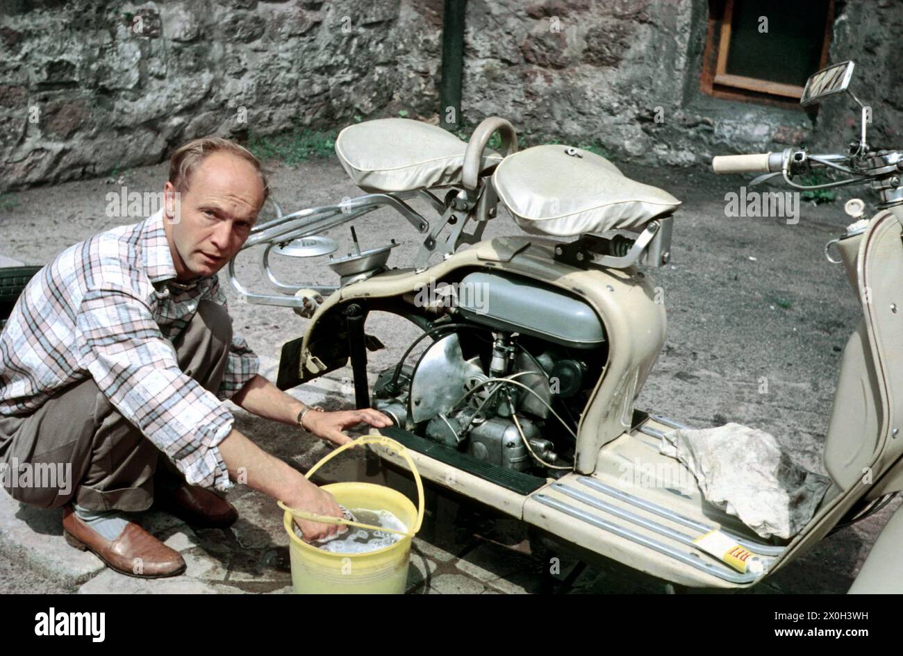A man when cleaning a Lambretta Stock Photo - Alamy