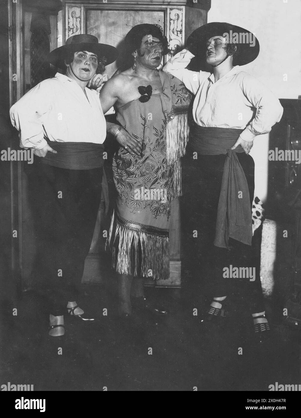 Two women in Spanish costumes and a man in a diva costume pose for the ...