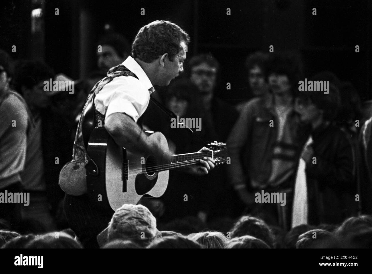 Before the concert, an audience member plays folk songs by Bob Dylan ...