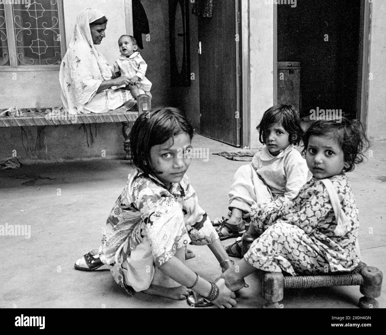 In the courtyard of a Pakistani family, the older sister helps the ...