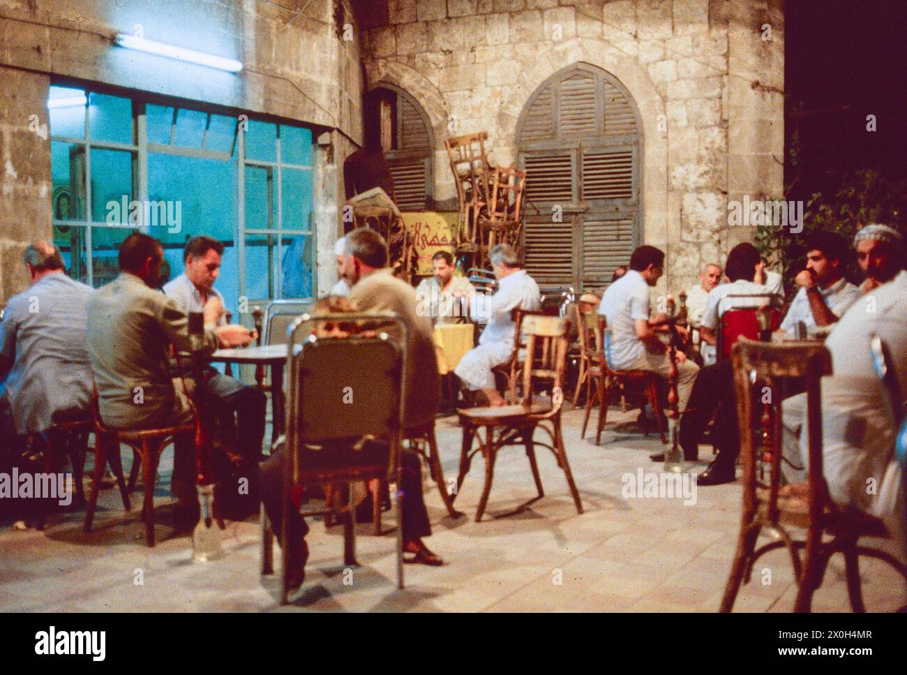 Men sit in a Syrian coffee house, playing cards and smoking shisha ...