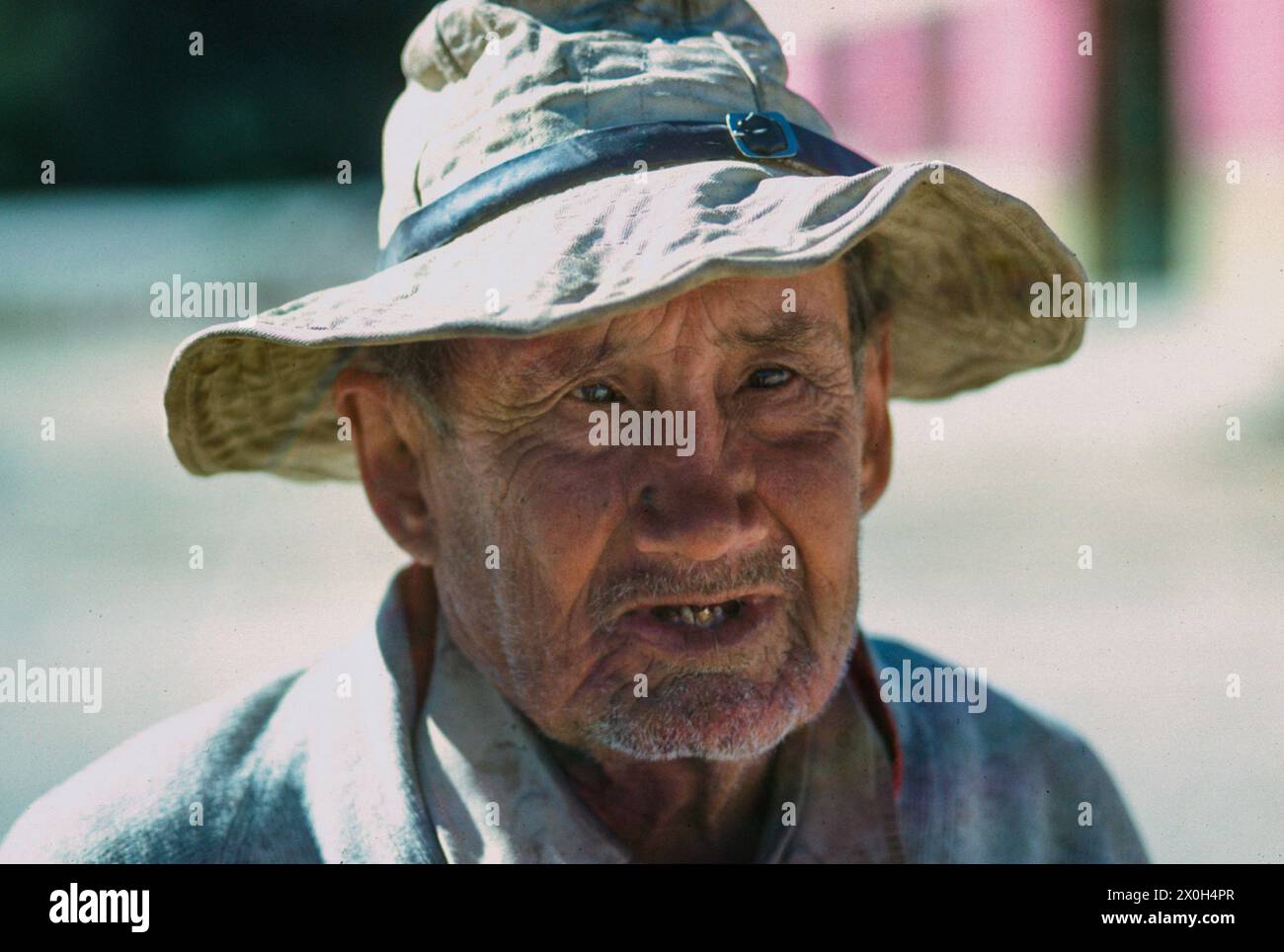 Protecting his head from the sun with a hat, this highlander strikes up ...