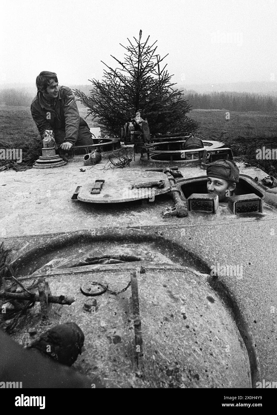 Troop exercise: Tank camouflaged with a fir tree. The gunner and loader ...