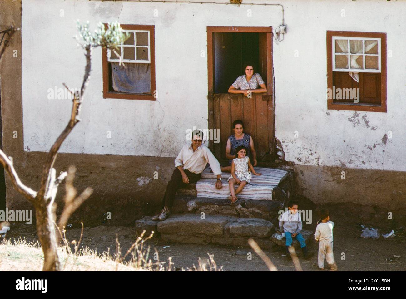 A family gathers on the steps outside their house in Portugal in the ...